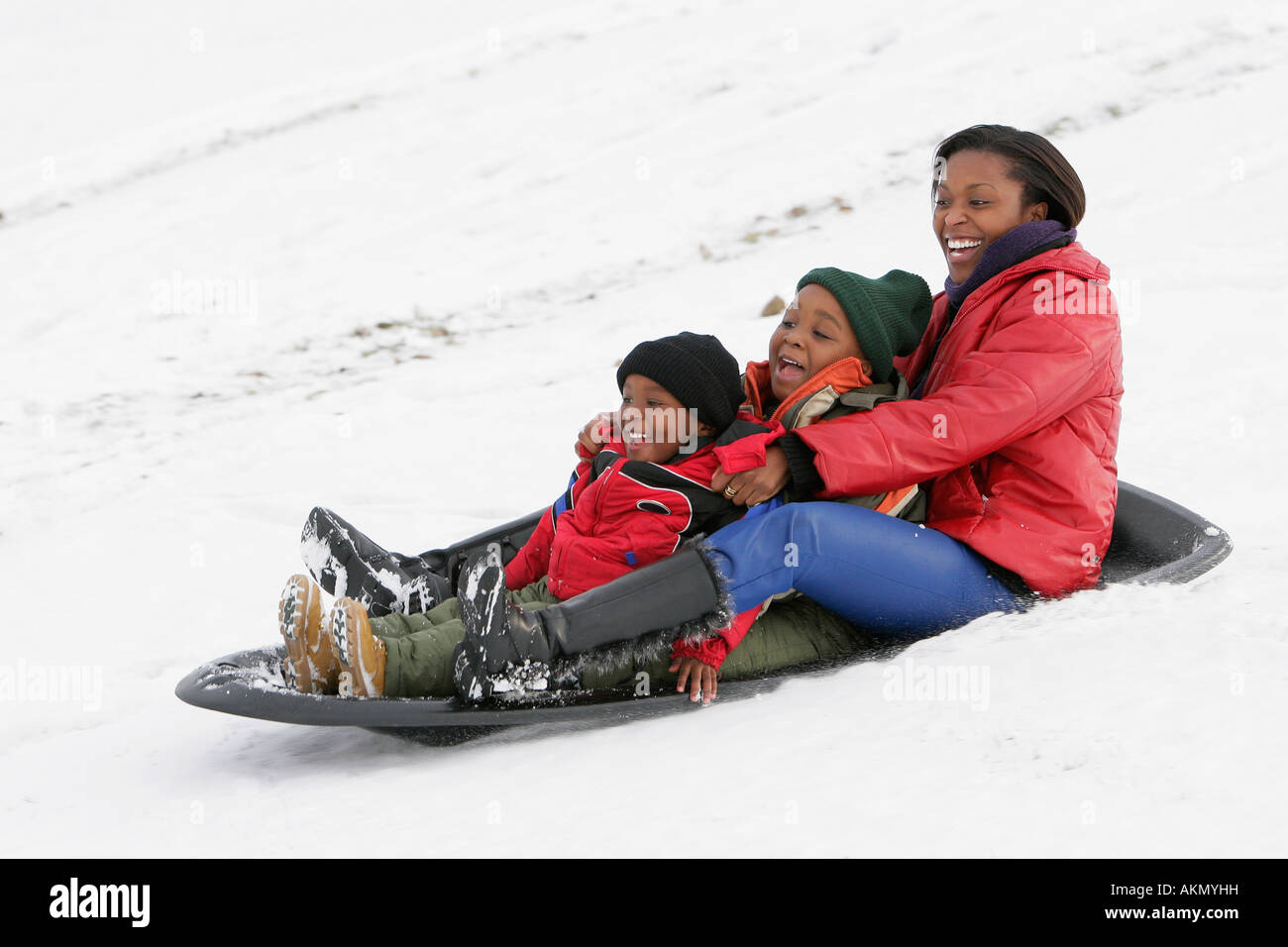Mother and children sledding on snow Stock Photo - Alamy