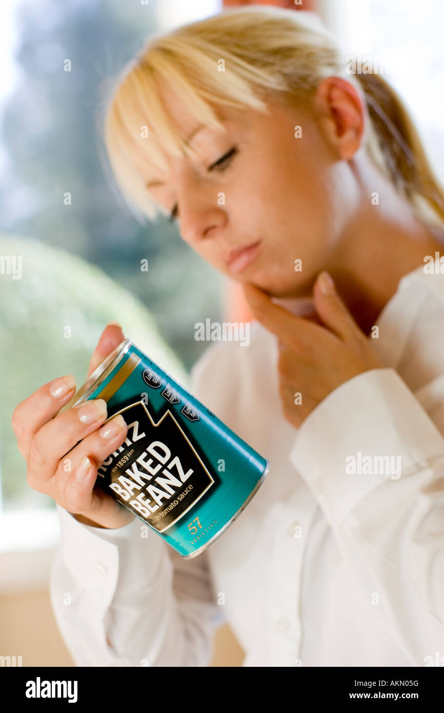 Woman reading label on Tin can Stock Photo - Alamy