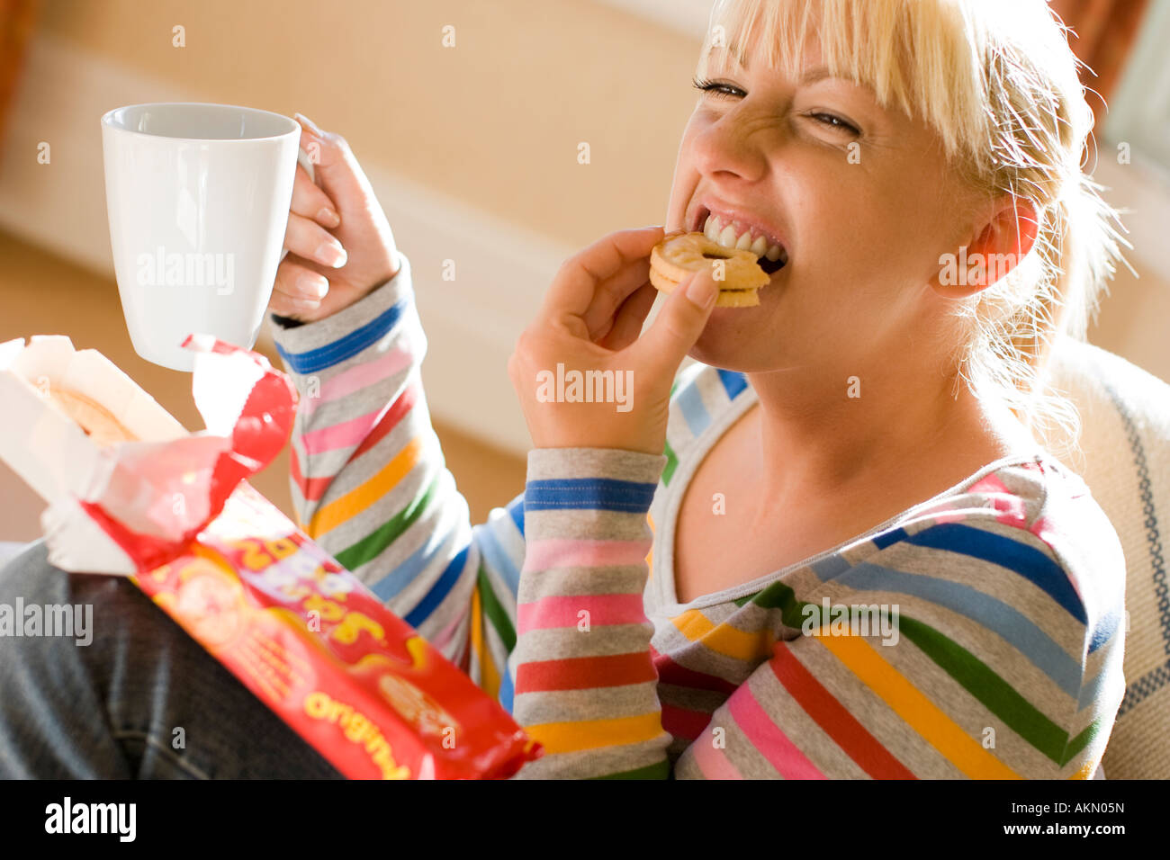 Woman eating biscuits with drink Stock Photo - Alamy