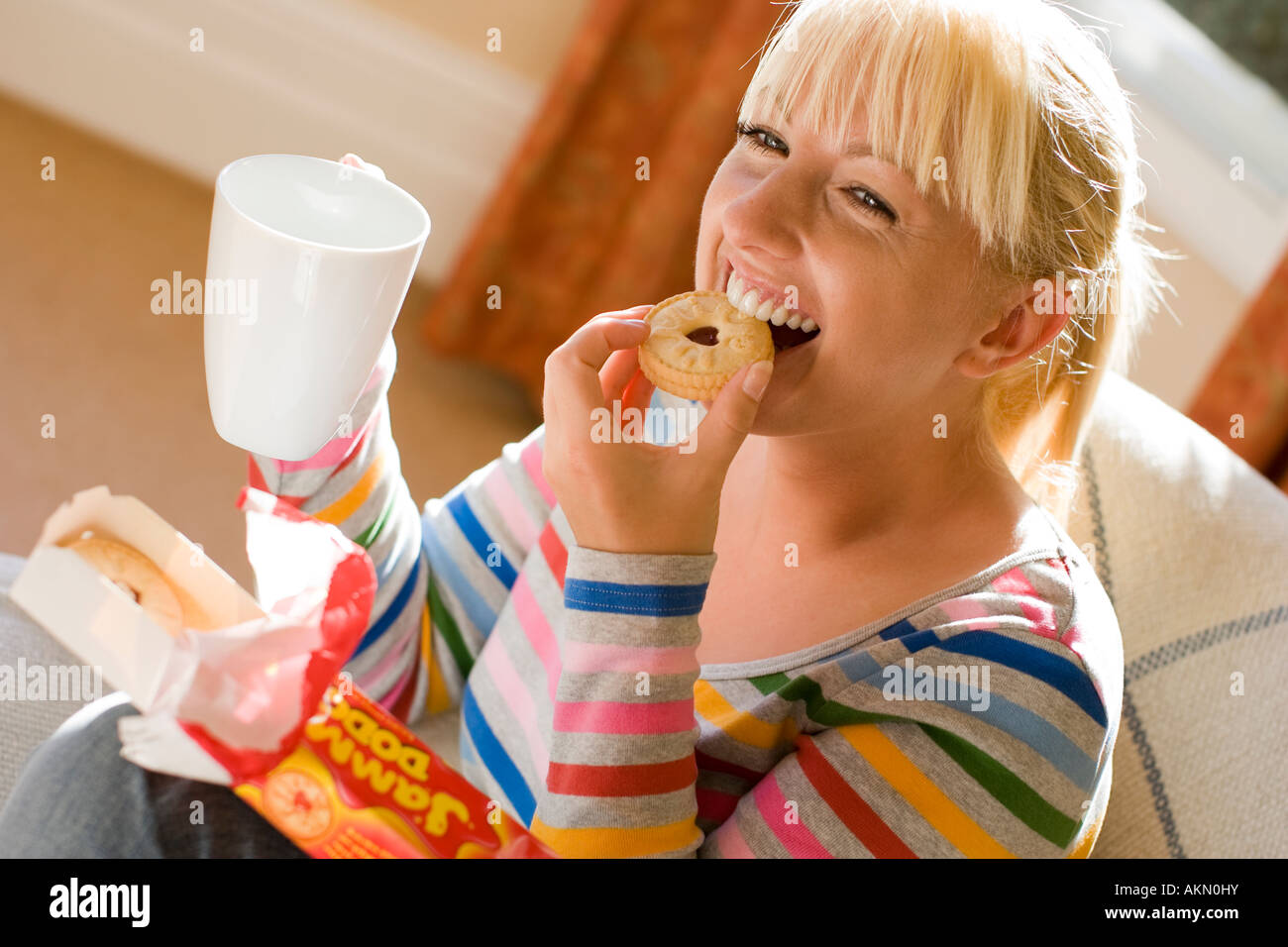 Woman eating biscuits with drink Stock Photo - Alamy
