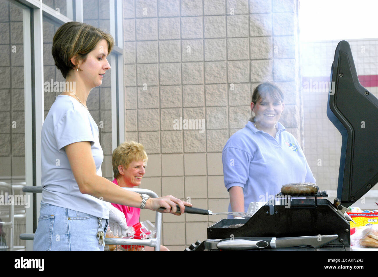 Female Sam s Club employee cooks burgers and dogs for March of Dimes ...