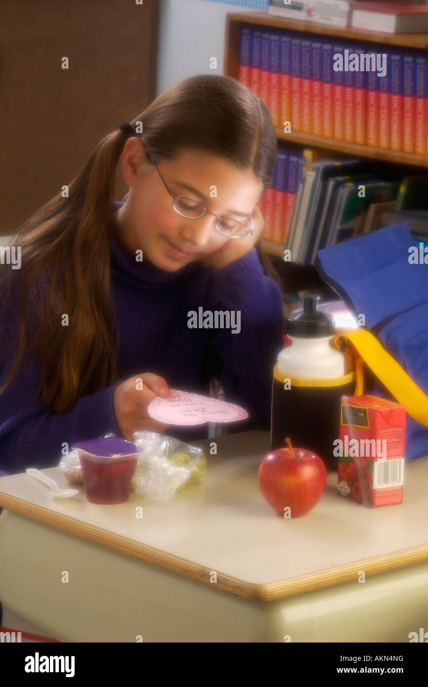 Girl eating lunch at desk Stock Photo - Alamy