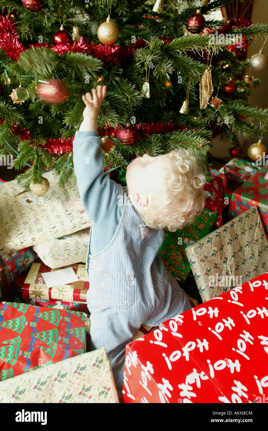 Child with presents under a christmas tree Stock Photo - Alamy