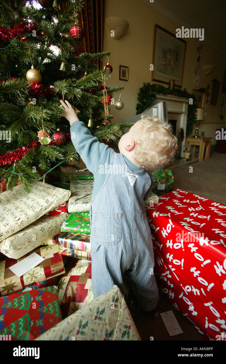 Child with presents under a christmas tree Stock Photo - Alamy