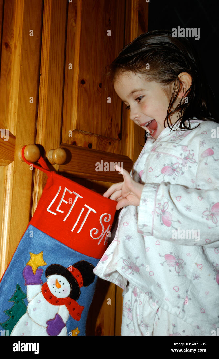 A little girl opens her stocking full of presents on Christmas morning ...