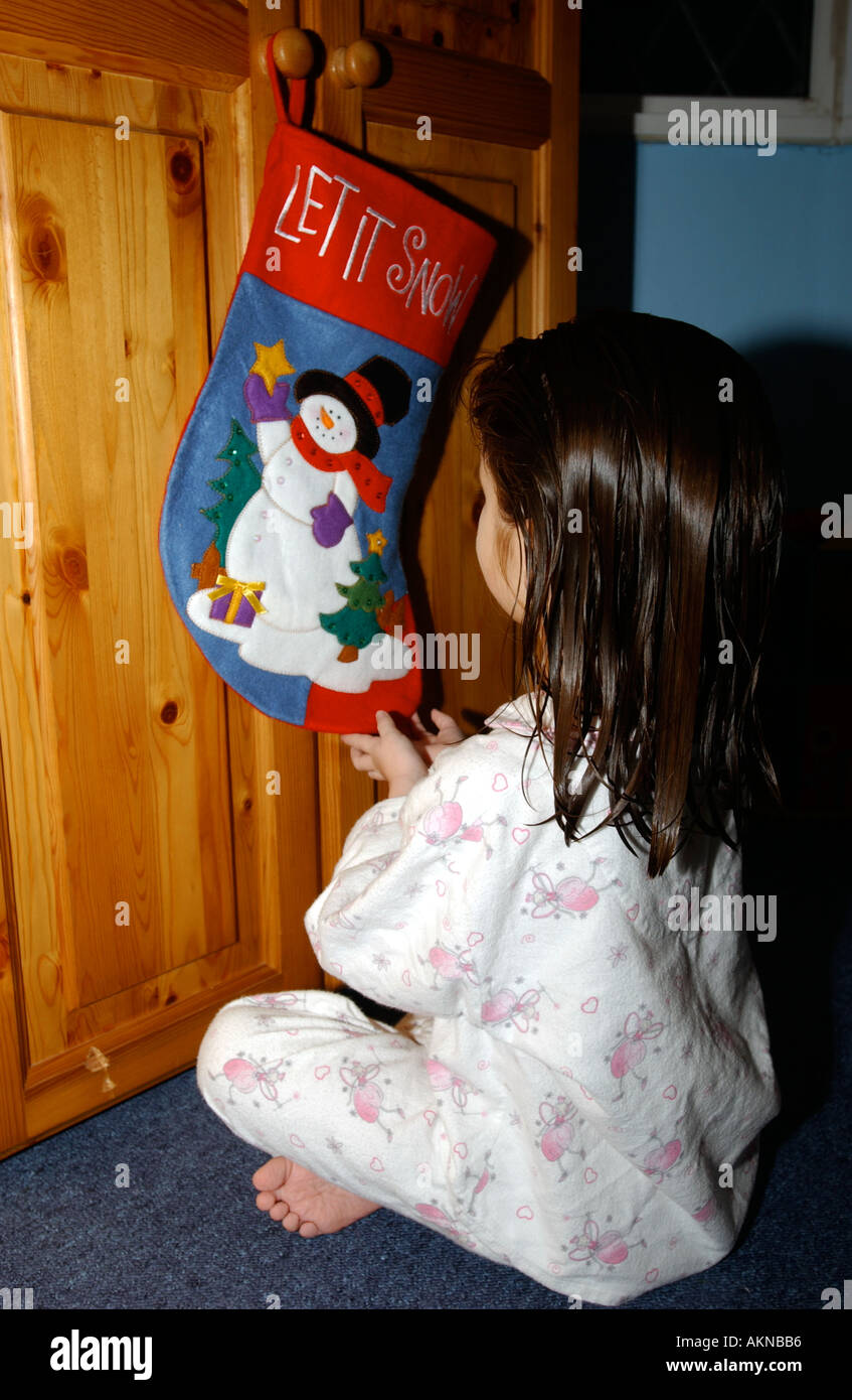A little girl opens her stocking full of presents on Christmas morning ...