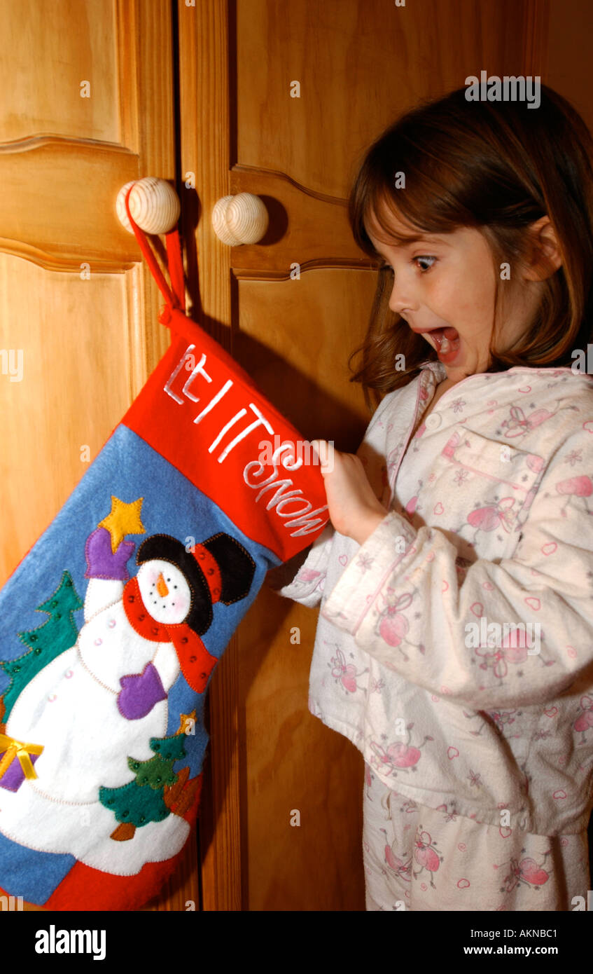 Christmas stocking. A little girl opens her stocking full of presents ...