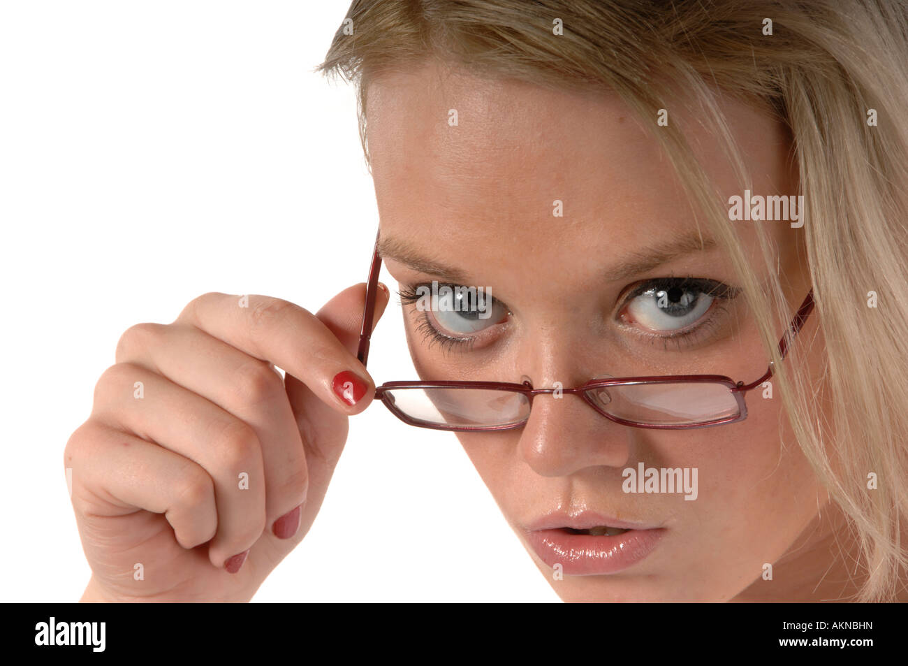 Blonde women looking over glasses holding on to the frame Stock Photo ...