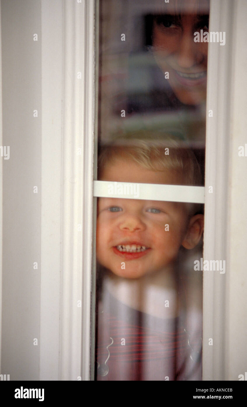 Pre school boy looking through window Stock Photo - Alamy