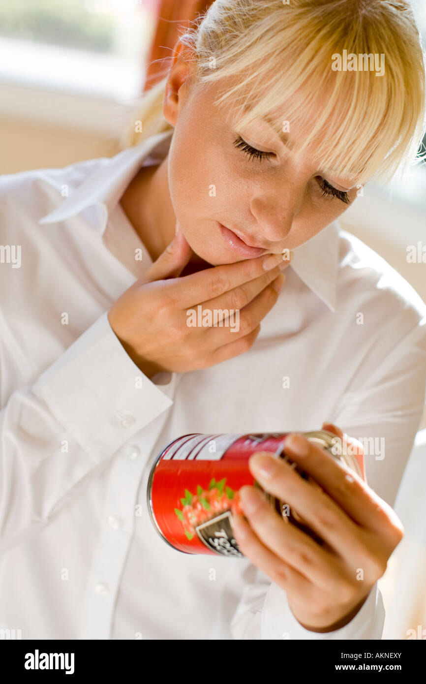 Woman reading label on Tin Stock Photo - Alamy