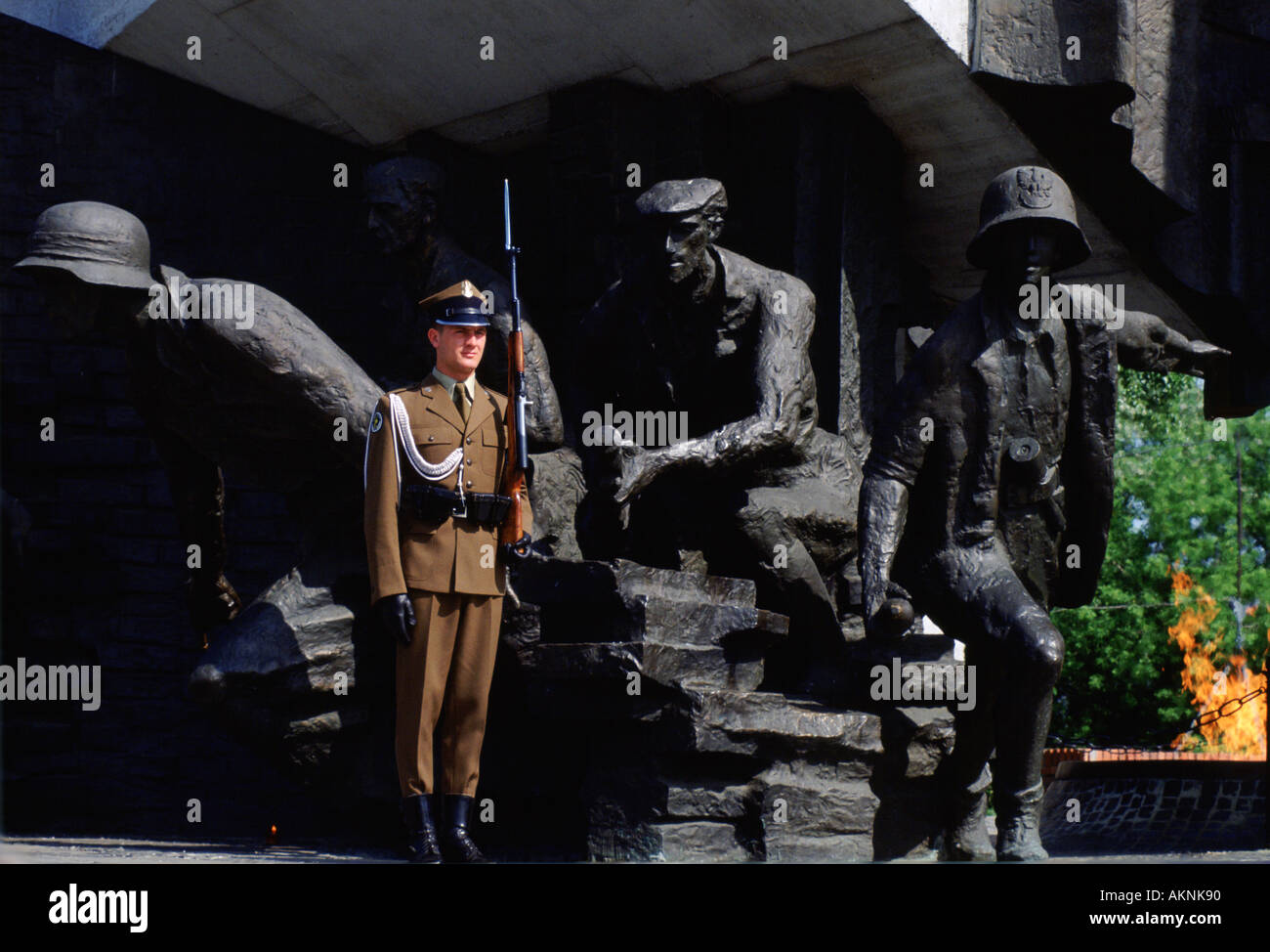 Soldier stands at attention with a rifle to guard the Warsaw Uprising ...