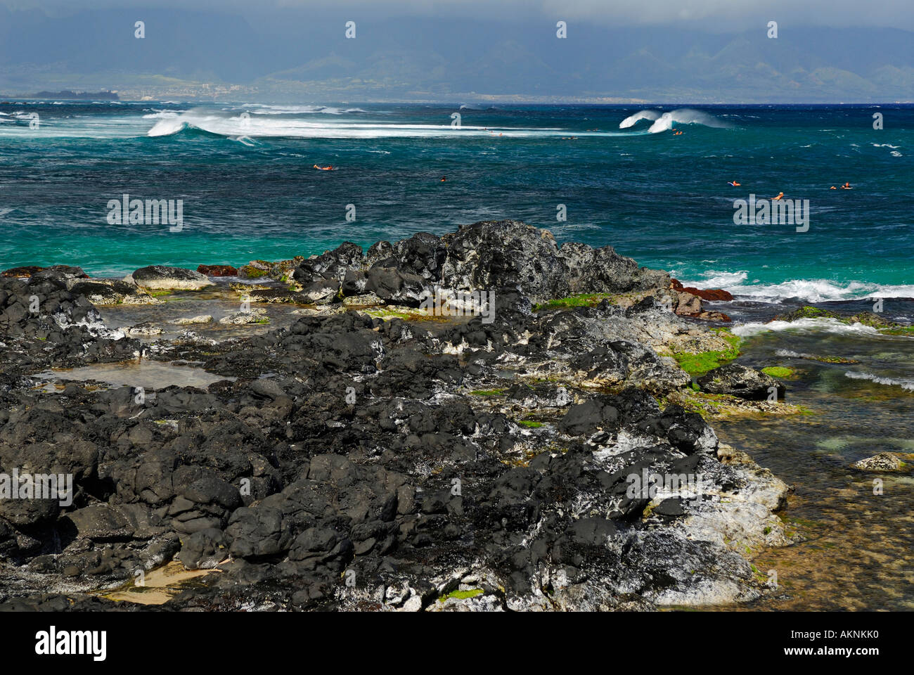Tide pools with group of surfers in large waves and Kahalui at Hookipa ...