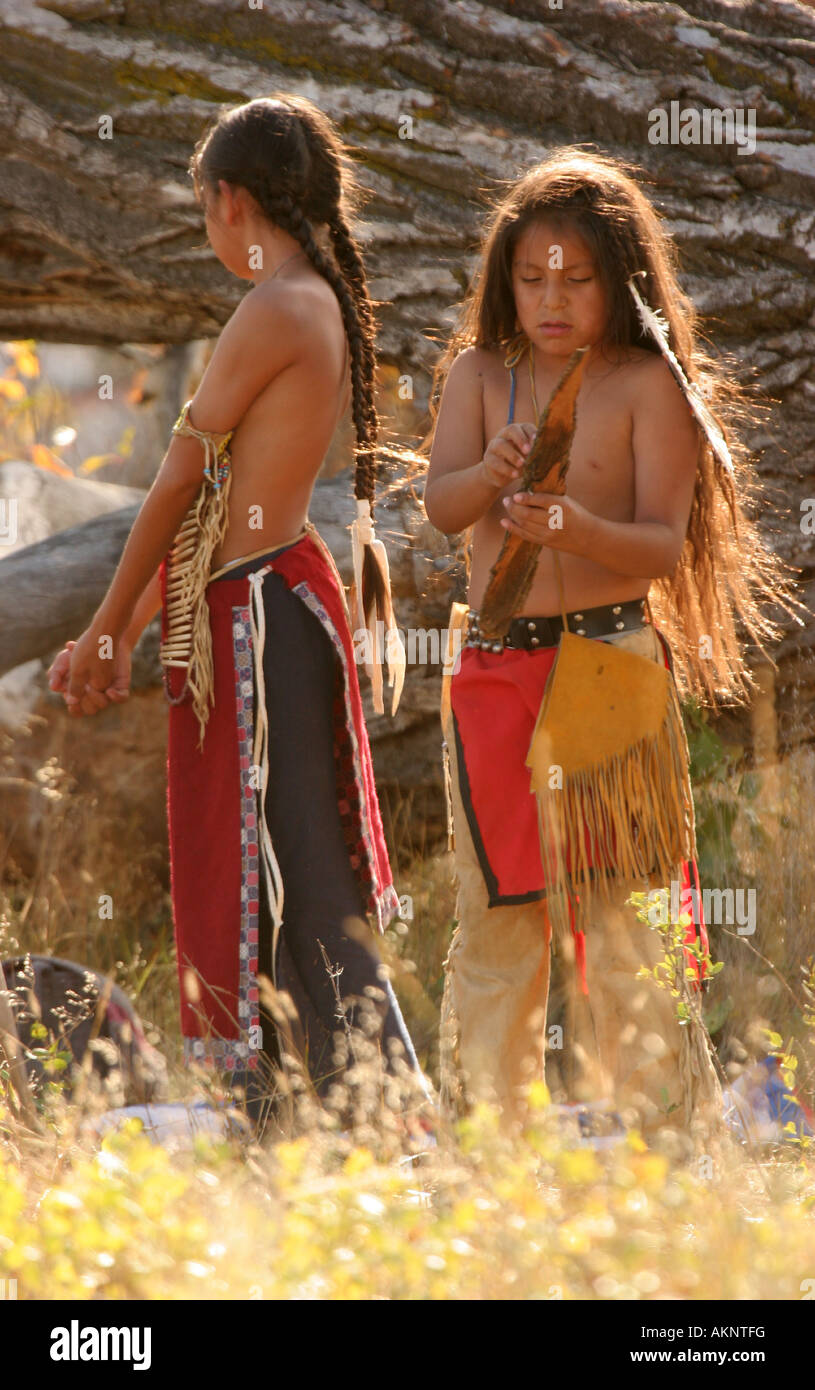 Two young Native American Indian boys playing with sticks by a large fallen willow tree Stock ...