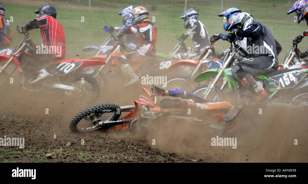 A rider falling off his bike at a Moto X competition with lots of dirt ...