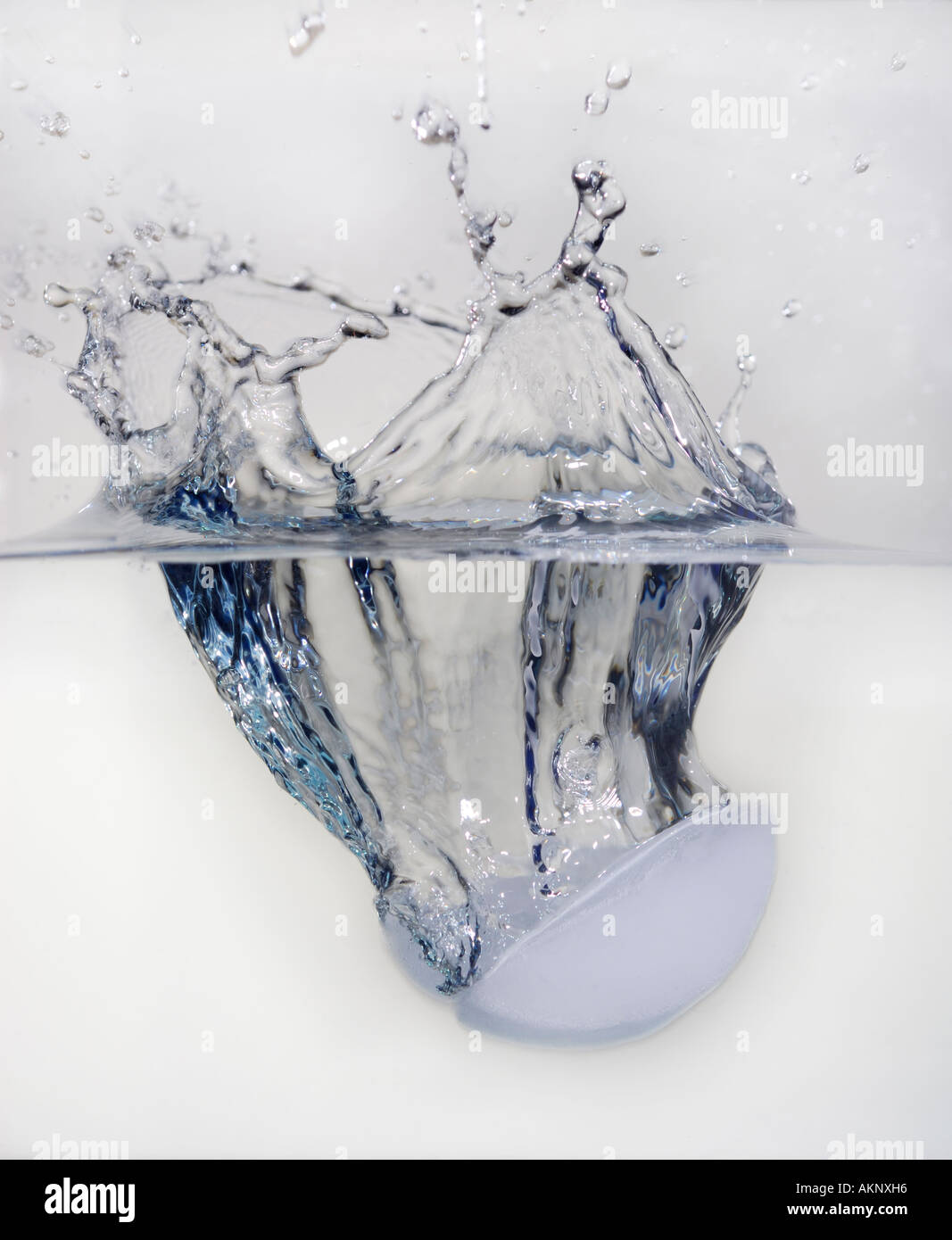 Stop motion of splash of Ice cubes dropped into a water tank on white ...