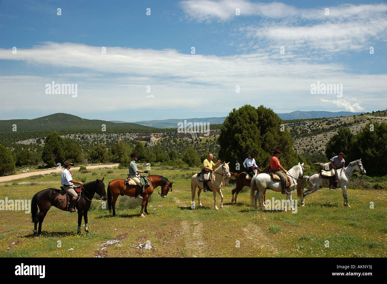 A group of vagabond horseman take a breather on a ridge overlooking the ...