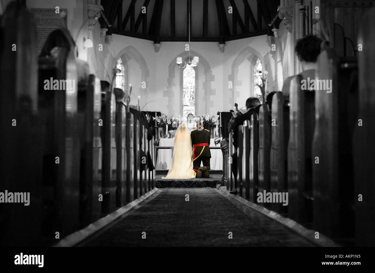 Bride and groom kneel at altar during typical catholic wedding ceremony ...