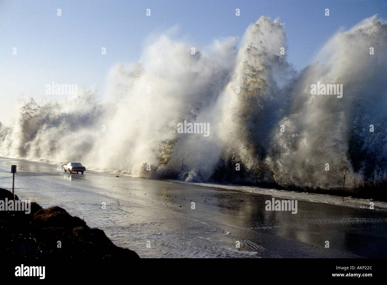 A huge storm surge wave dwarfs a car traveling on Highway 1 at Solimar ...