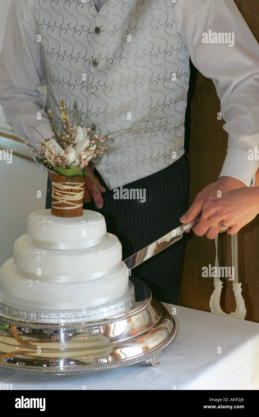 A bride and groom cut the wedding cake on their wedding day at their ...