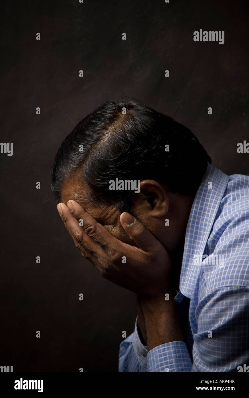 Indian man head in hands Stock Photo - Alamy