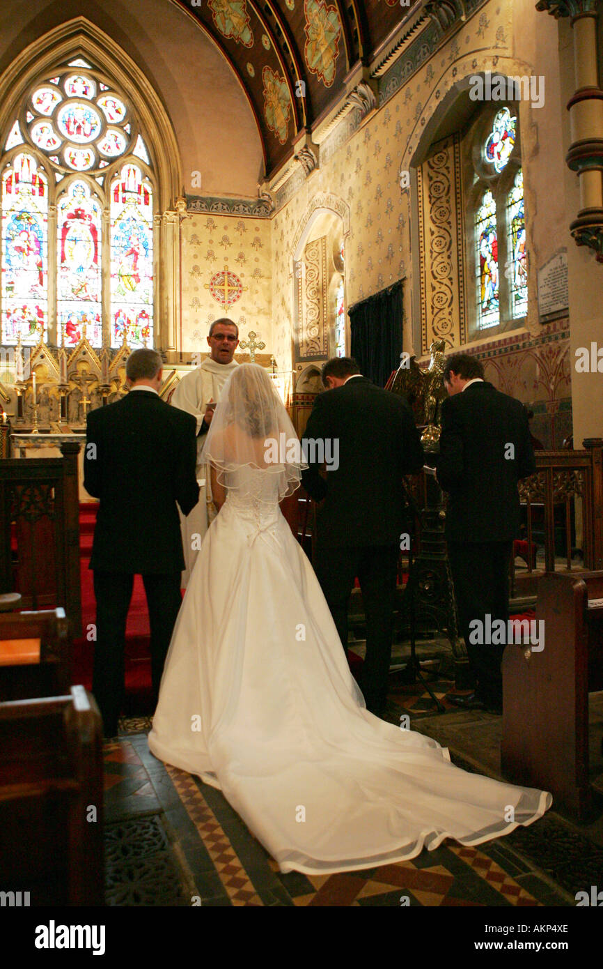 A Bride and Groom in traditional clothing stand at the altar during ...