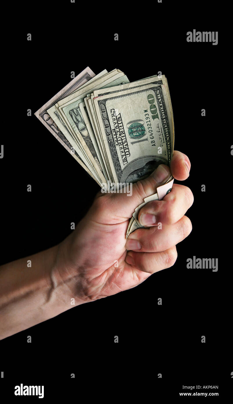 Hand grasping American money isolated on black Stock Photo - Alamy