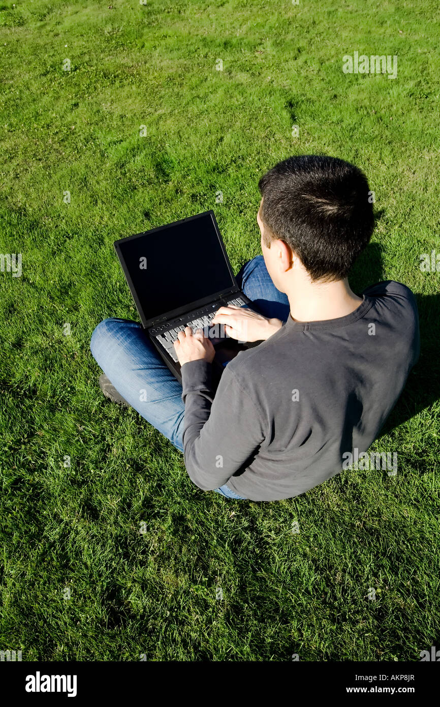 Young man typing in the computer outdoors Stock Photo - Alamy