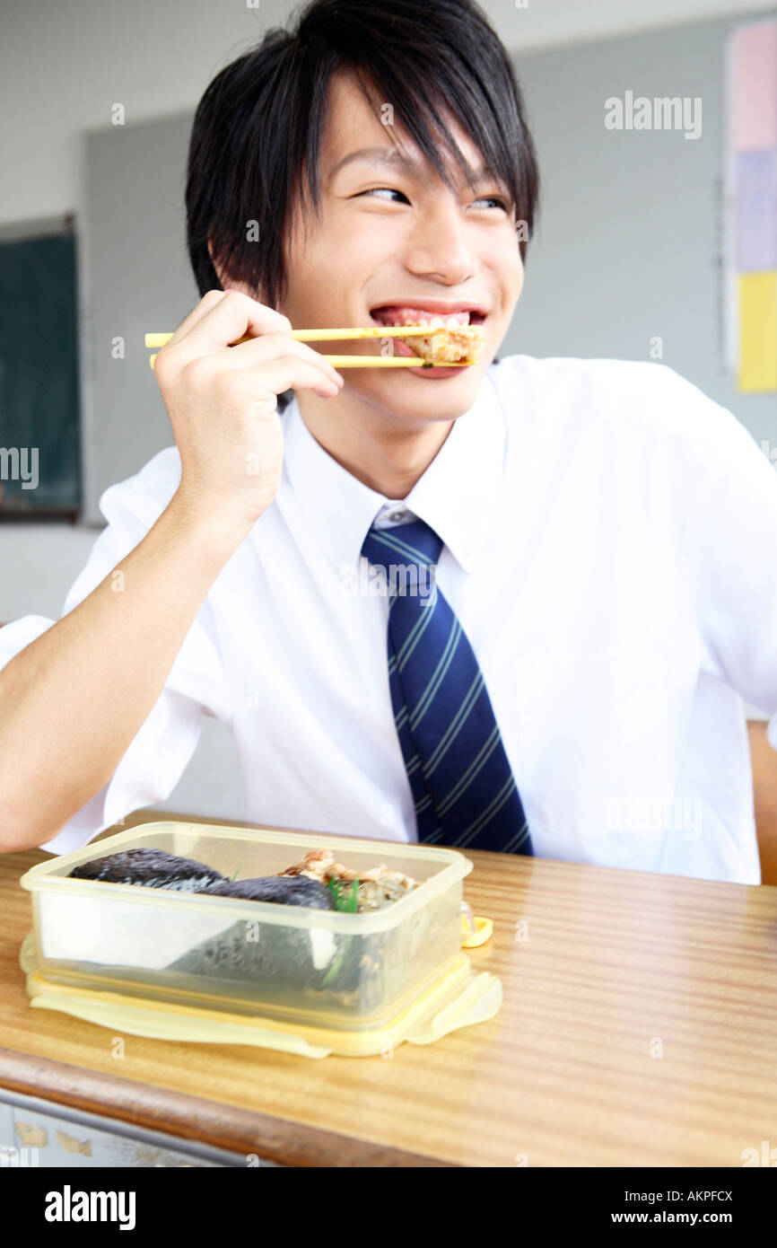 High school boy eating box lunch Stock Photo - Alamy