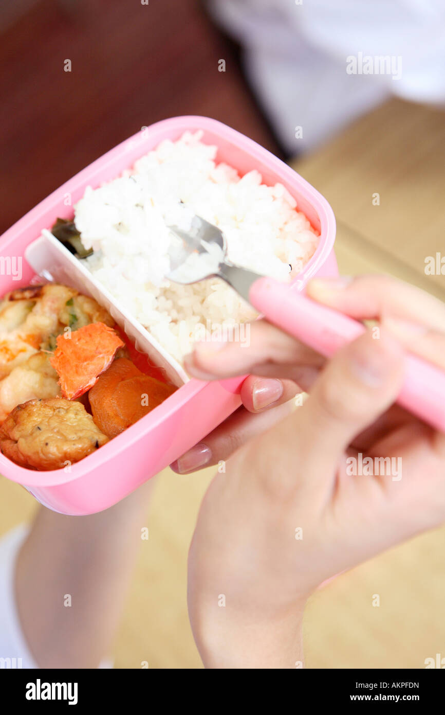 Hand of high school girl eating box lunch Stock Photo - Alamy