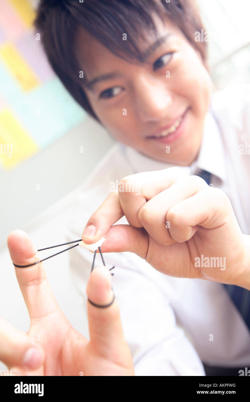 High school boy playing with rubber band Stock Photo - Alamy