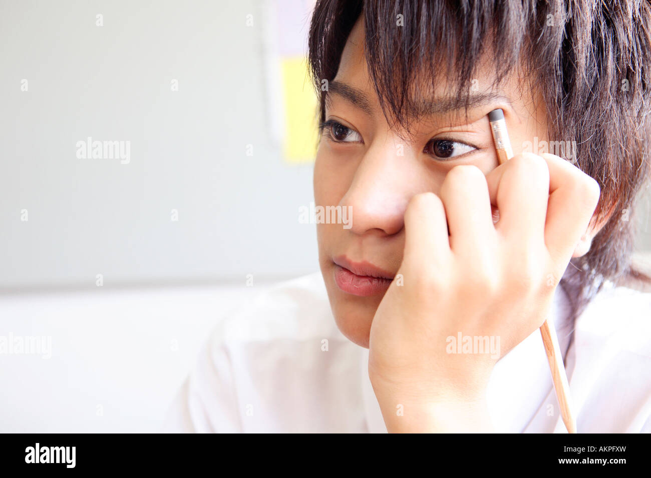 High school boy resting his cheek on his hand Stock Photo - Alamy