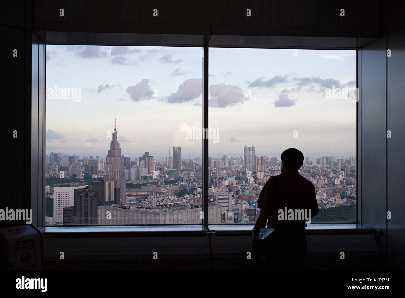 Person looking at city through window Stock Photo - Alamy