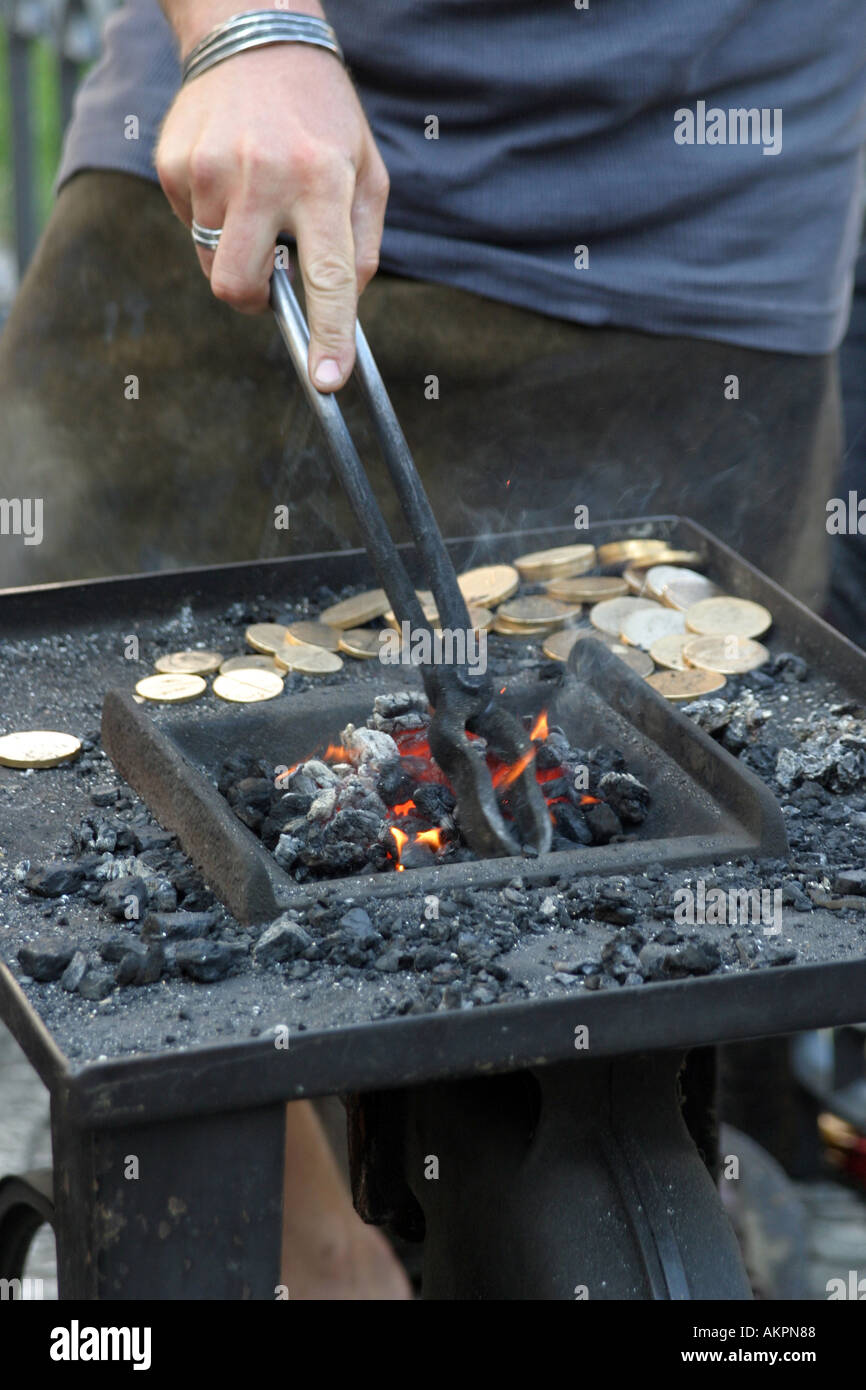 a blacksmith creating coins for tourists in the old town square in ...