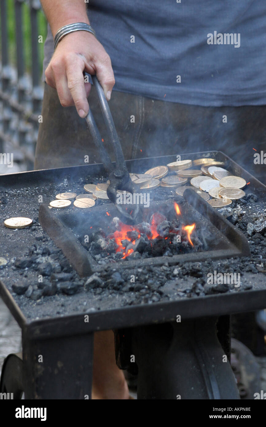 a blacksmith creating coins for tourists in the old town square in ...
