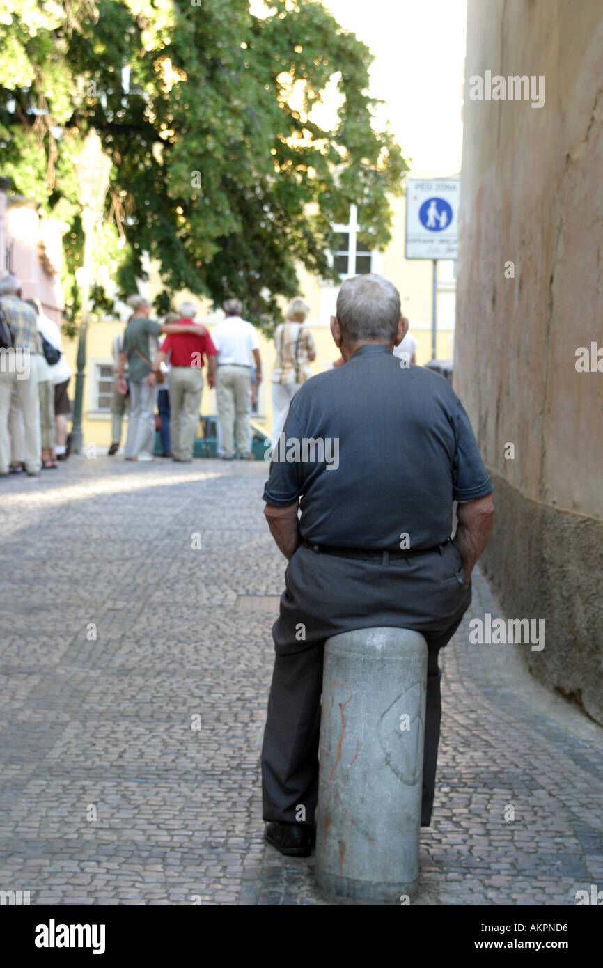 old man sitting on a concrete post in mala strana in prague city Stock ...