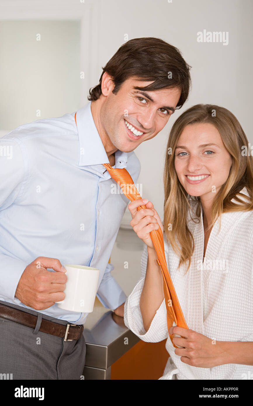 A woman pulling on a mans tie Stock Photo - Alamy