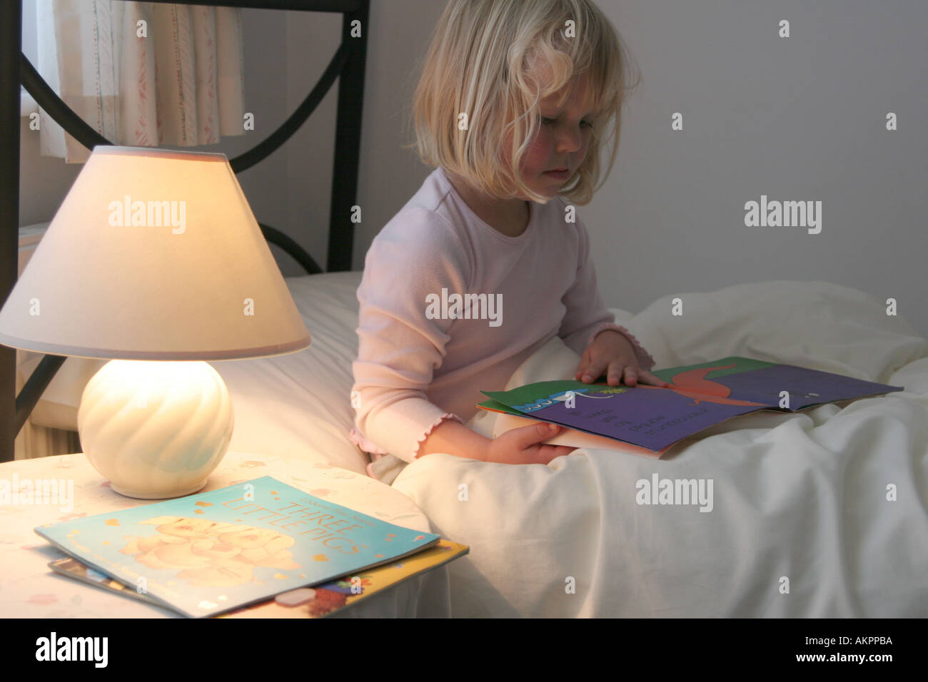 young girl reading book at bedtime Stock Photo - Alamy