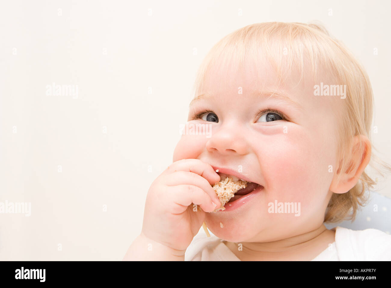 A baby boy eating a biscuit Stock Photo - Alamy