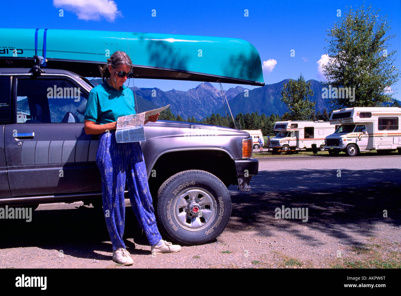 Woman reading a Map and planning a Travel Trip at a Campground in the ...