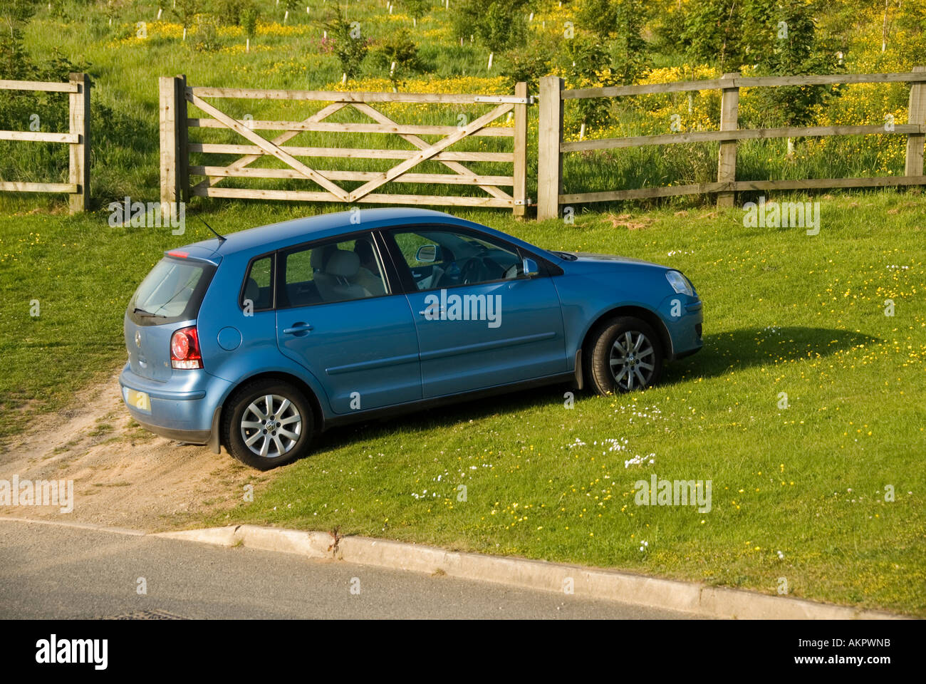 Blue Volkswagen five door hatchback Polo car parked on grass verge ...