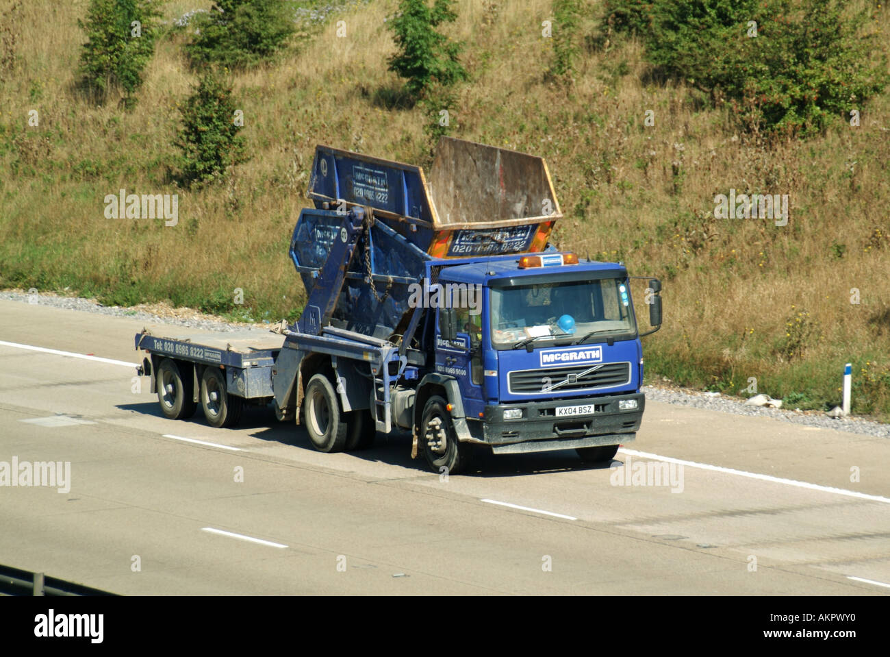 M25 motorway skip lorry with two empty bins and trailer Stock Photo - Alamy