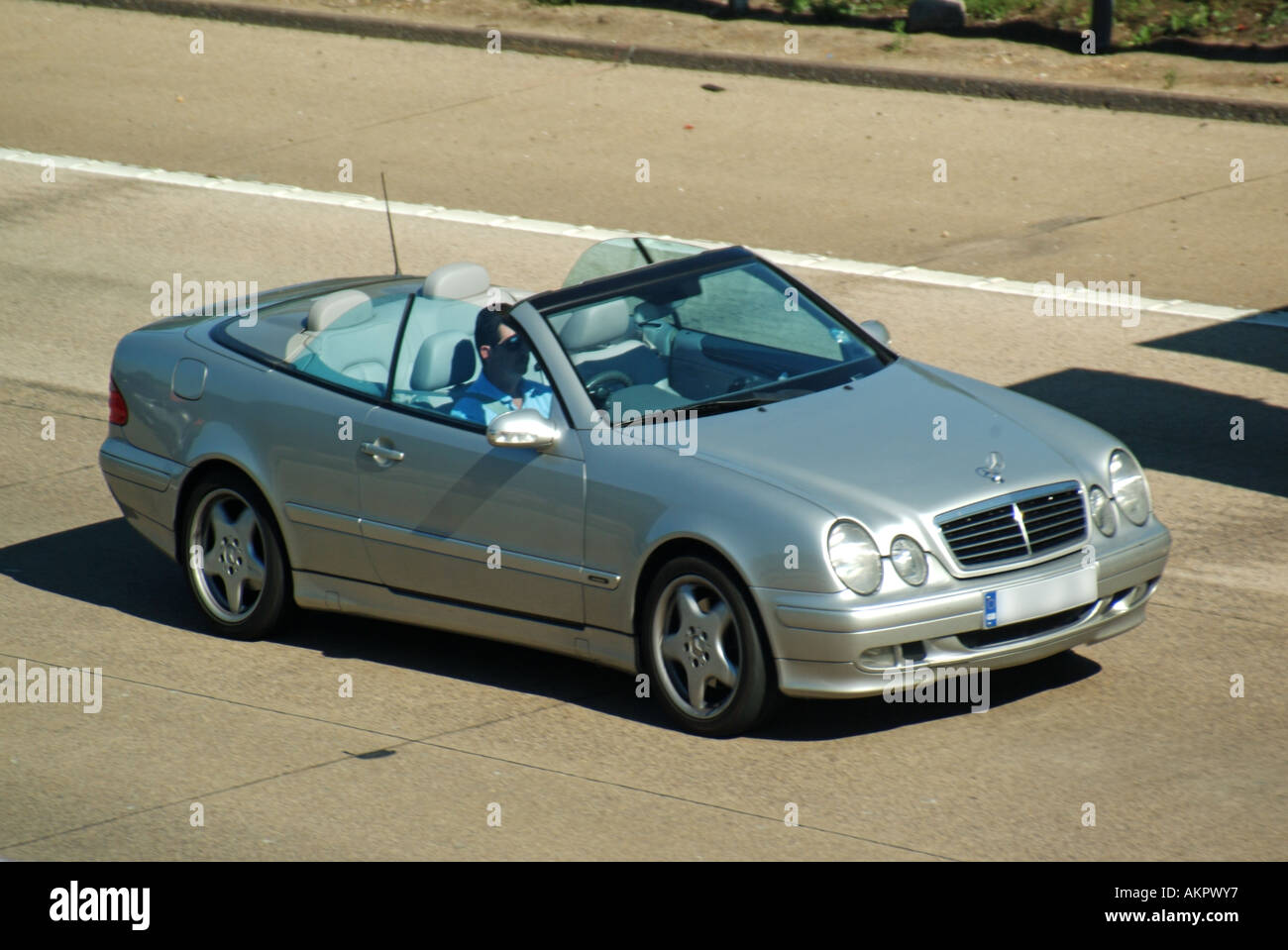 M25 motorway convertible car at speed with hood down in warm weather ...