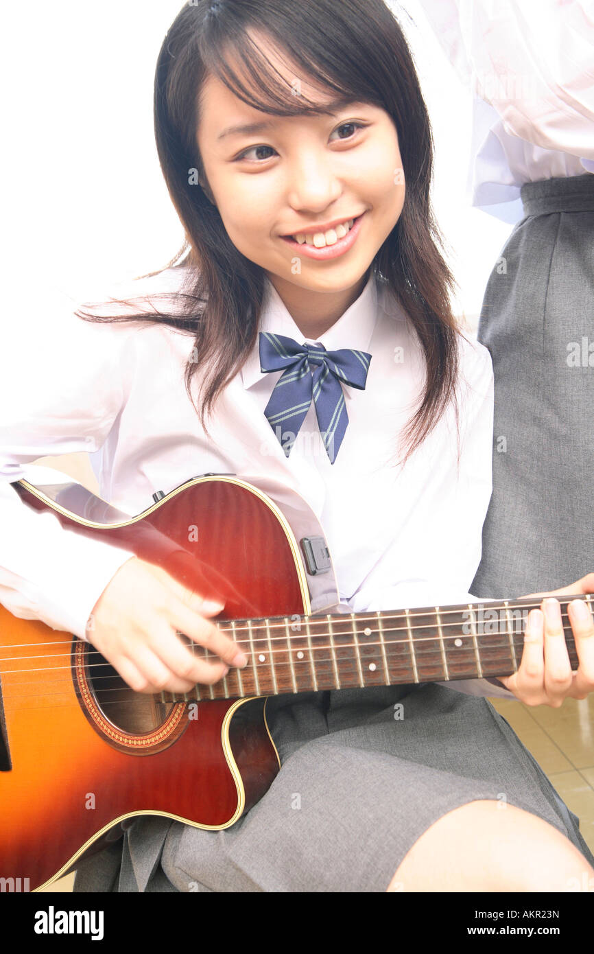 Girls' high school student playing guitar Stock Photo - Alamy