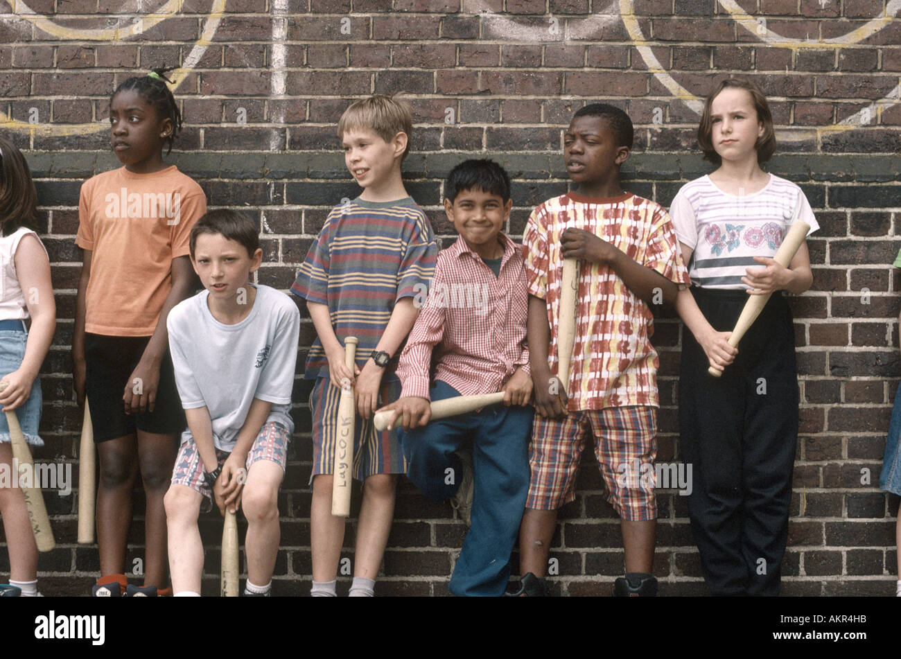 primary children queuing up to play rounders in the school playground ...