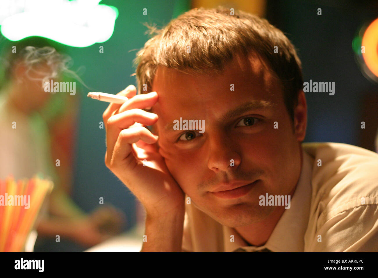 Young man smoking in the bar Stock Photo - Alamy