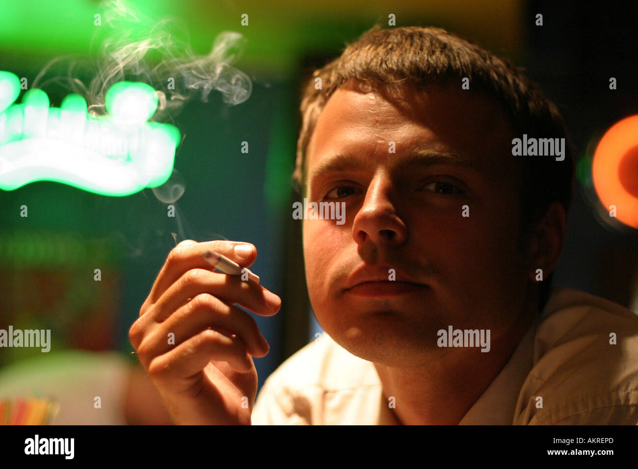 Young man smoking in the bar Stock Photo - Alamy