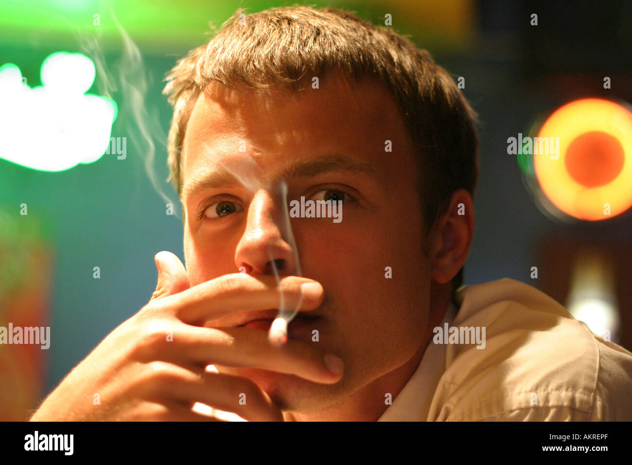 Young man smoking in the bar Stock Photo - Alamy