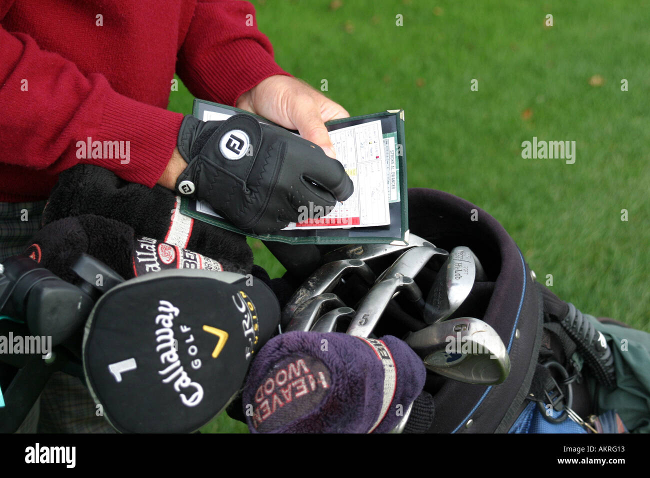golfer writing his score on a scorecard next to his clubs Stock Photo ...