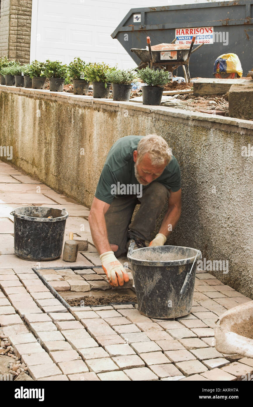 builder paving a path outside a house Stock Photo - Alamy