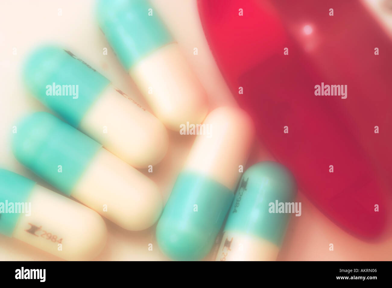 Close up of pill bottle with cream and blue capsules spilling from it ...
